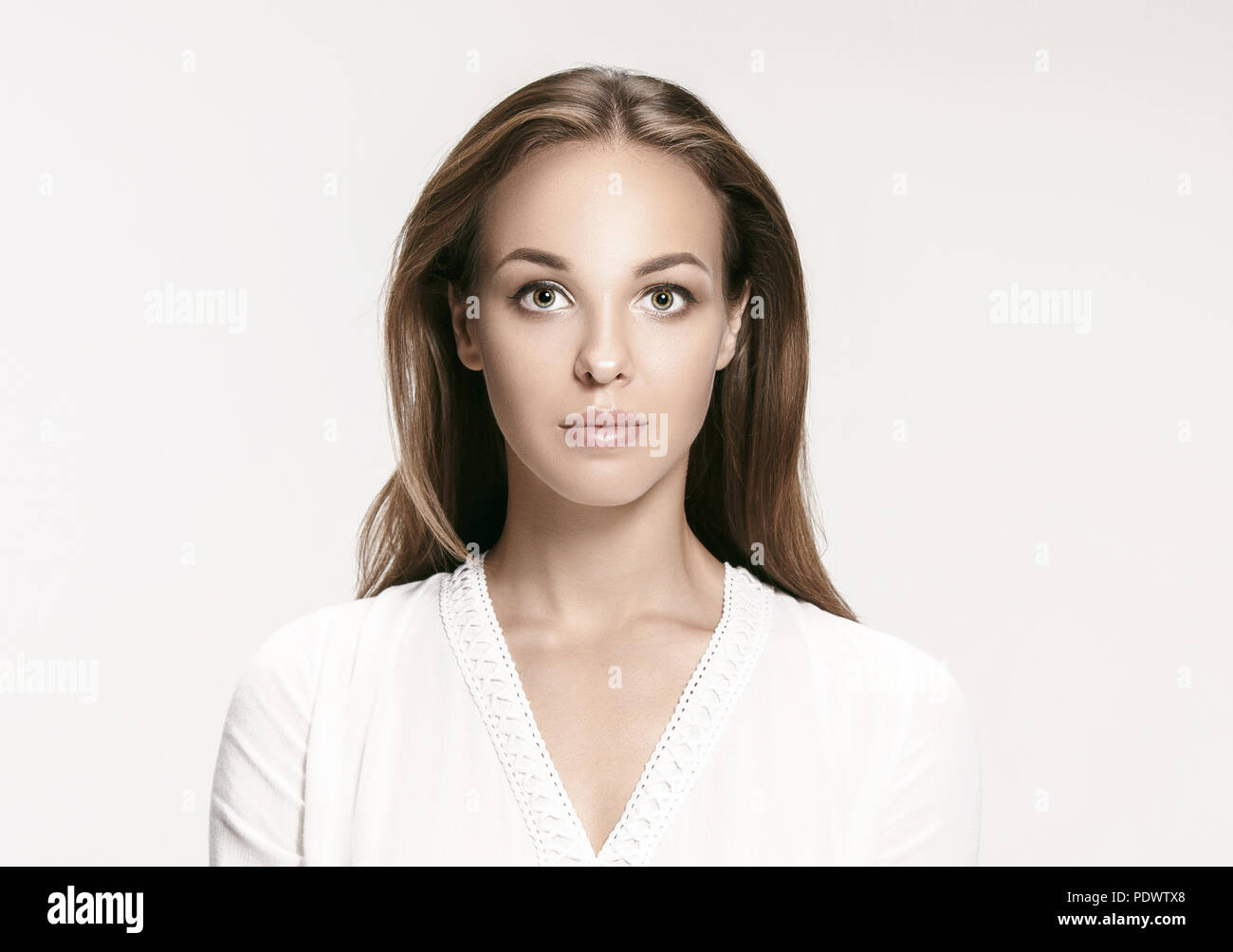 Serious business woman standing, looking at camera isolated on gray ...