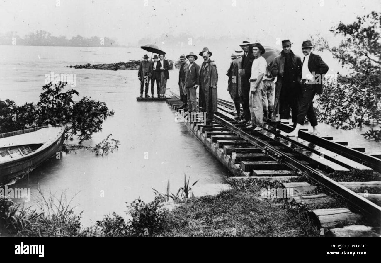 274 StateLibQld 1 84640 Group of men standing on the flooded railway ...
