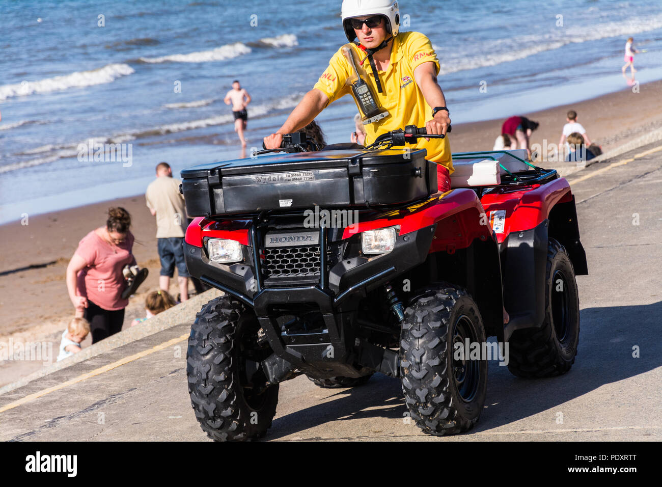 RNLI lifeguard on a quad bike patrolling Central Beach, Prestatyn ...
