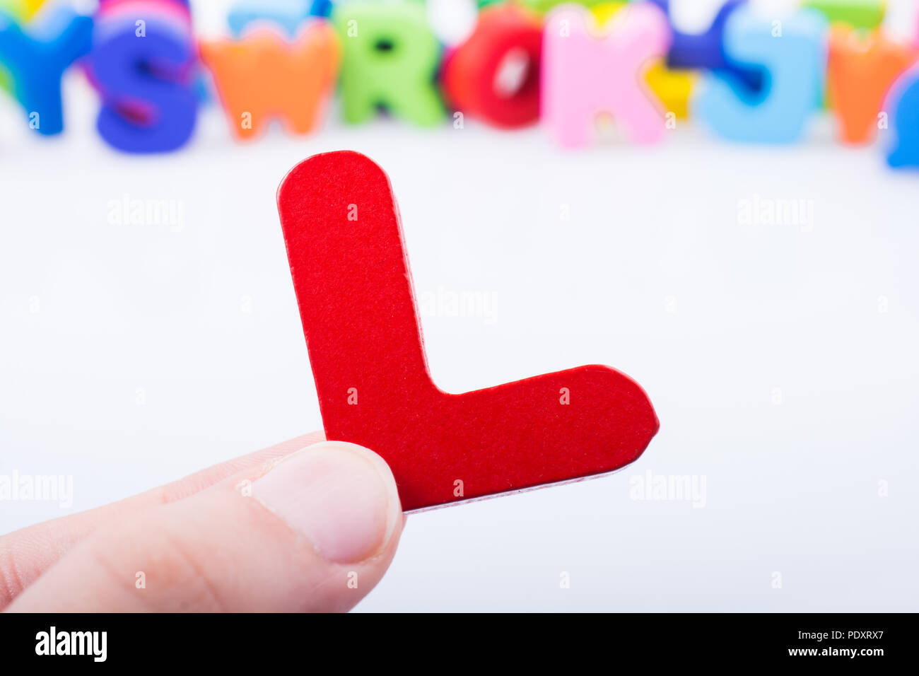Hand holding letter cube L of made of wood Stock Photo - Alamy
