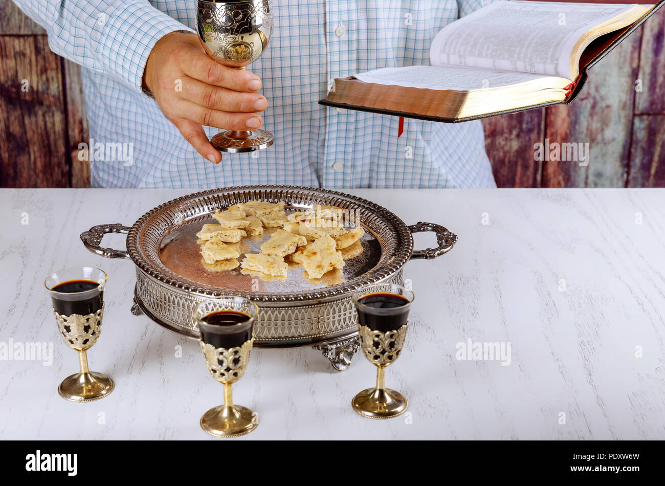Holy communion on table in church cup of glass with red wine and bread ...