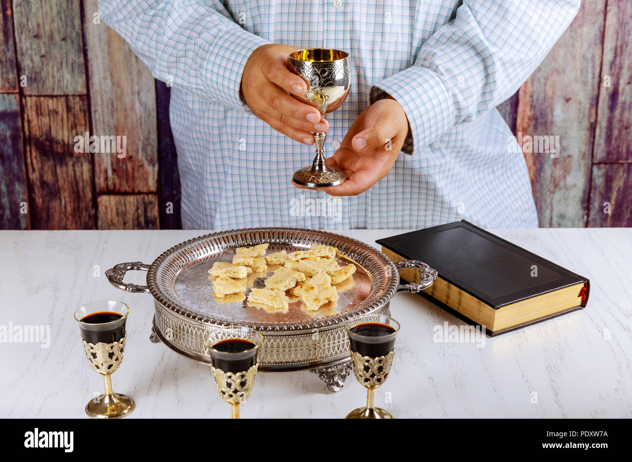 Holy communion cup of glass with red wine, bread and Holy Bible prayer ...