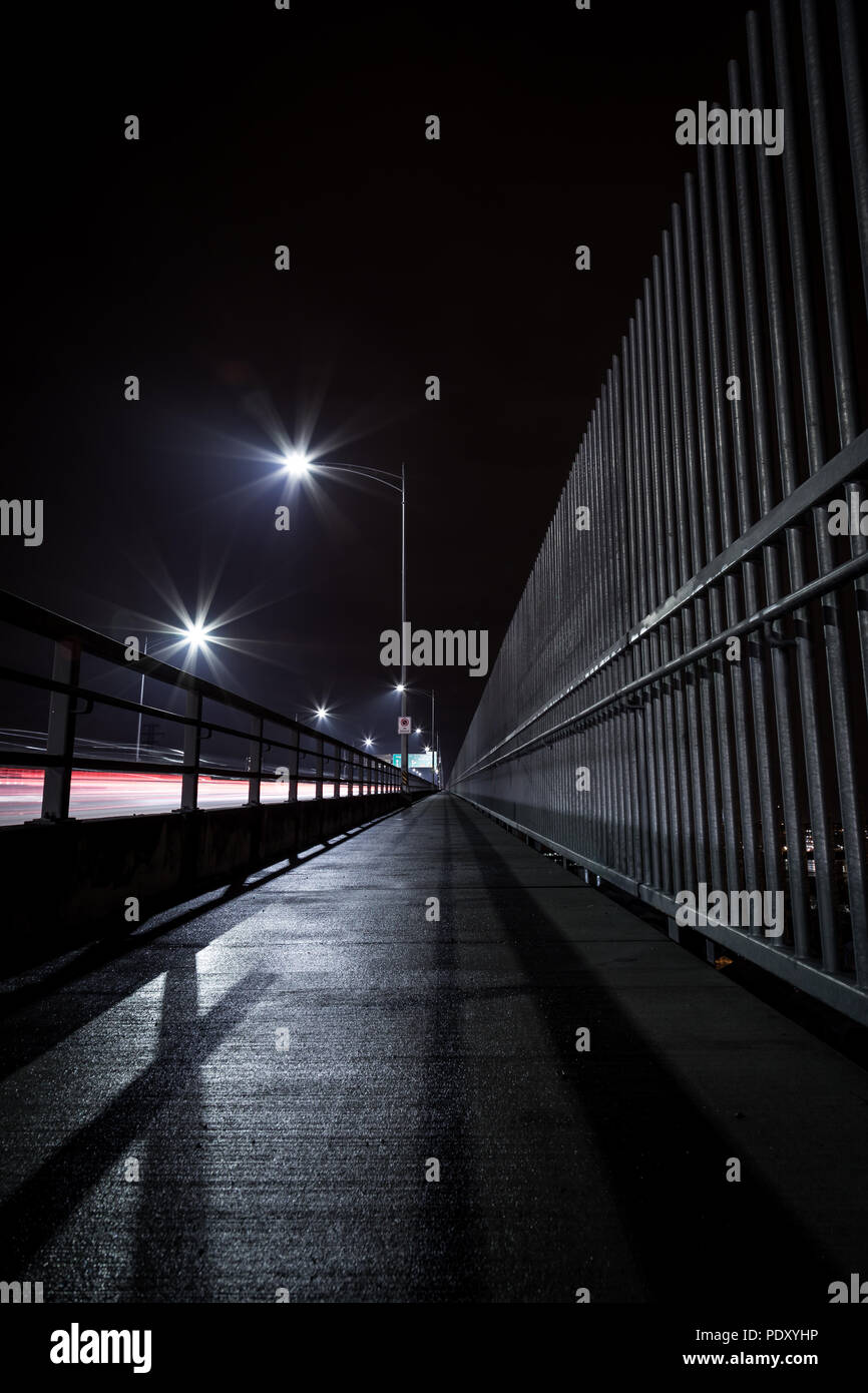 The Second Narrows Bridge sidewalk at night, with light trails from ...