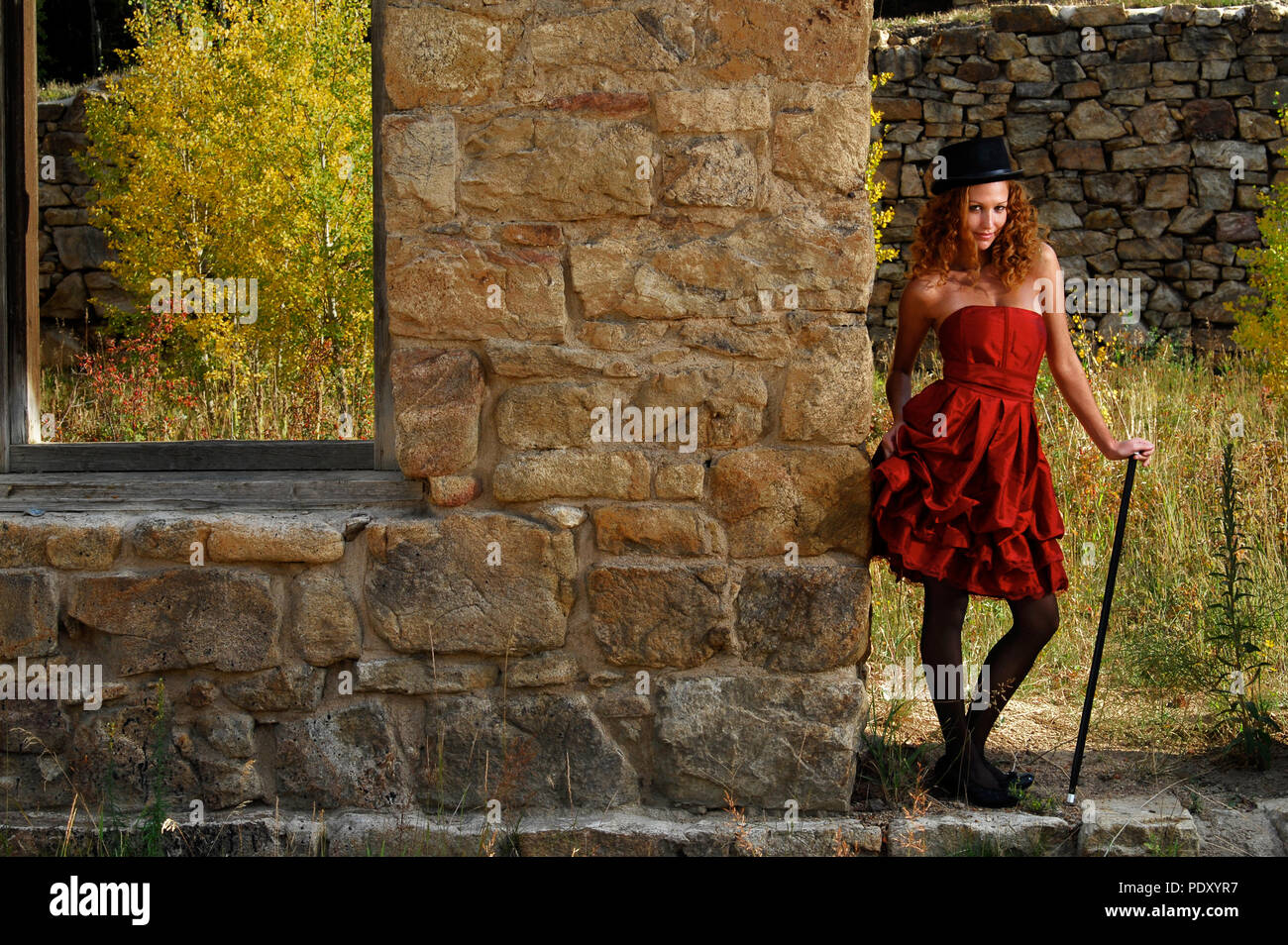 A beautiful red headed chorus girl in the ruins of an old ghost town ...