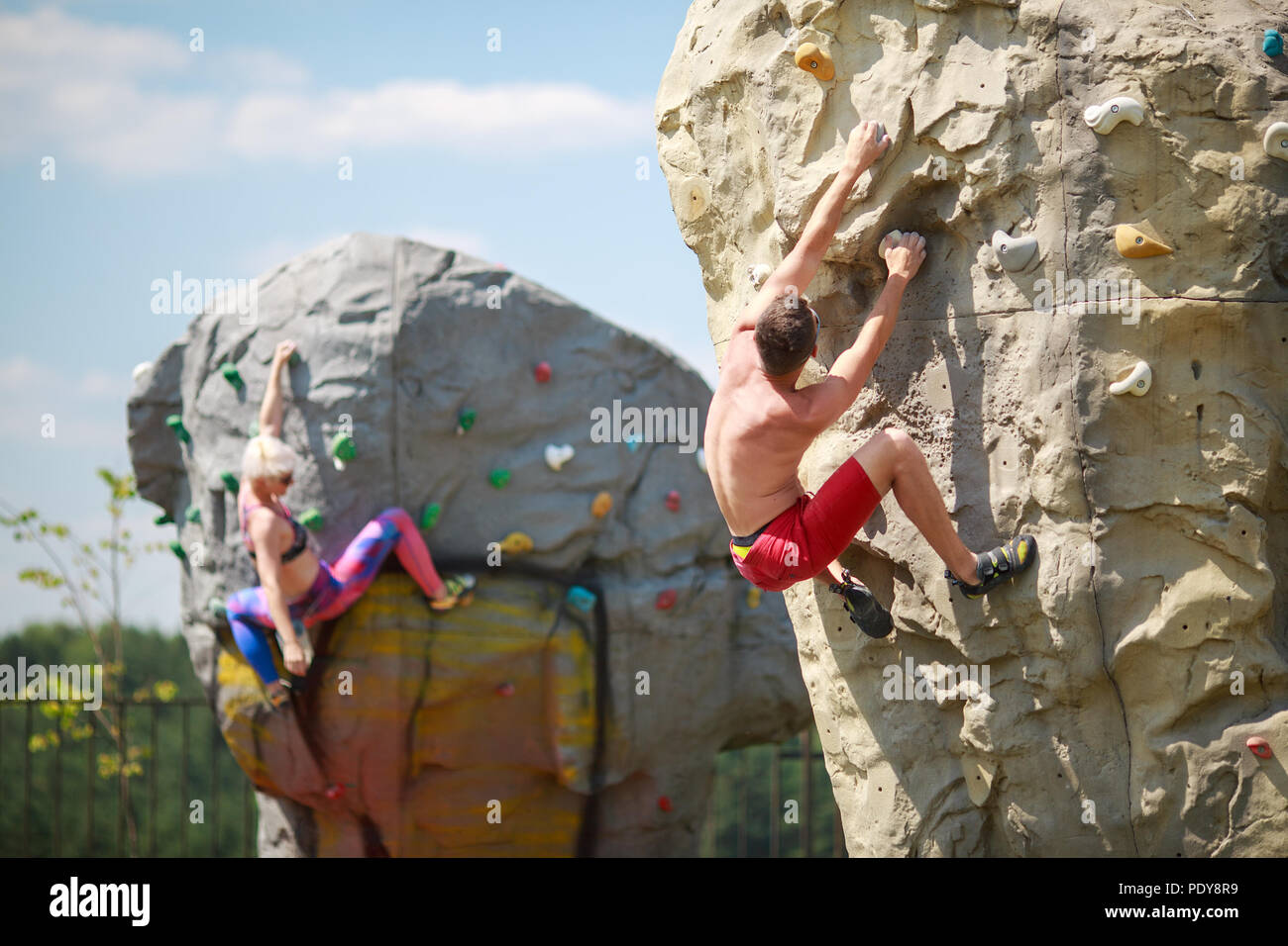 Photo from back of sports man in red shorts and woman on workout at ...