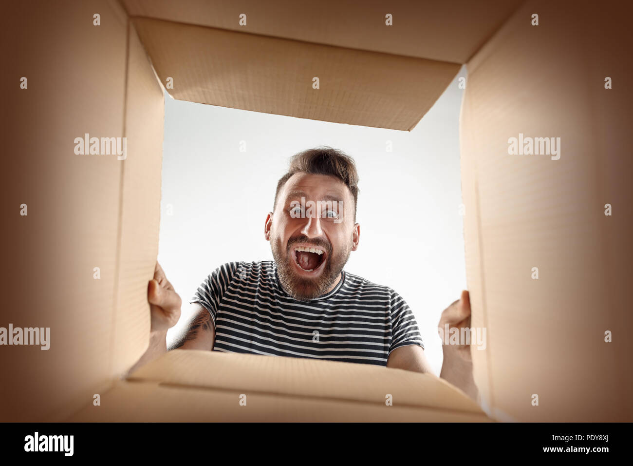 The surprised man opening carton box and looking inside. The package ...