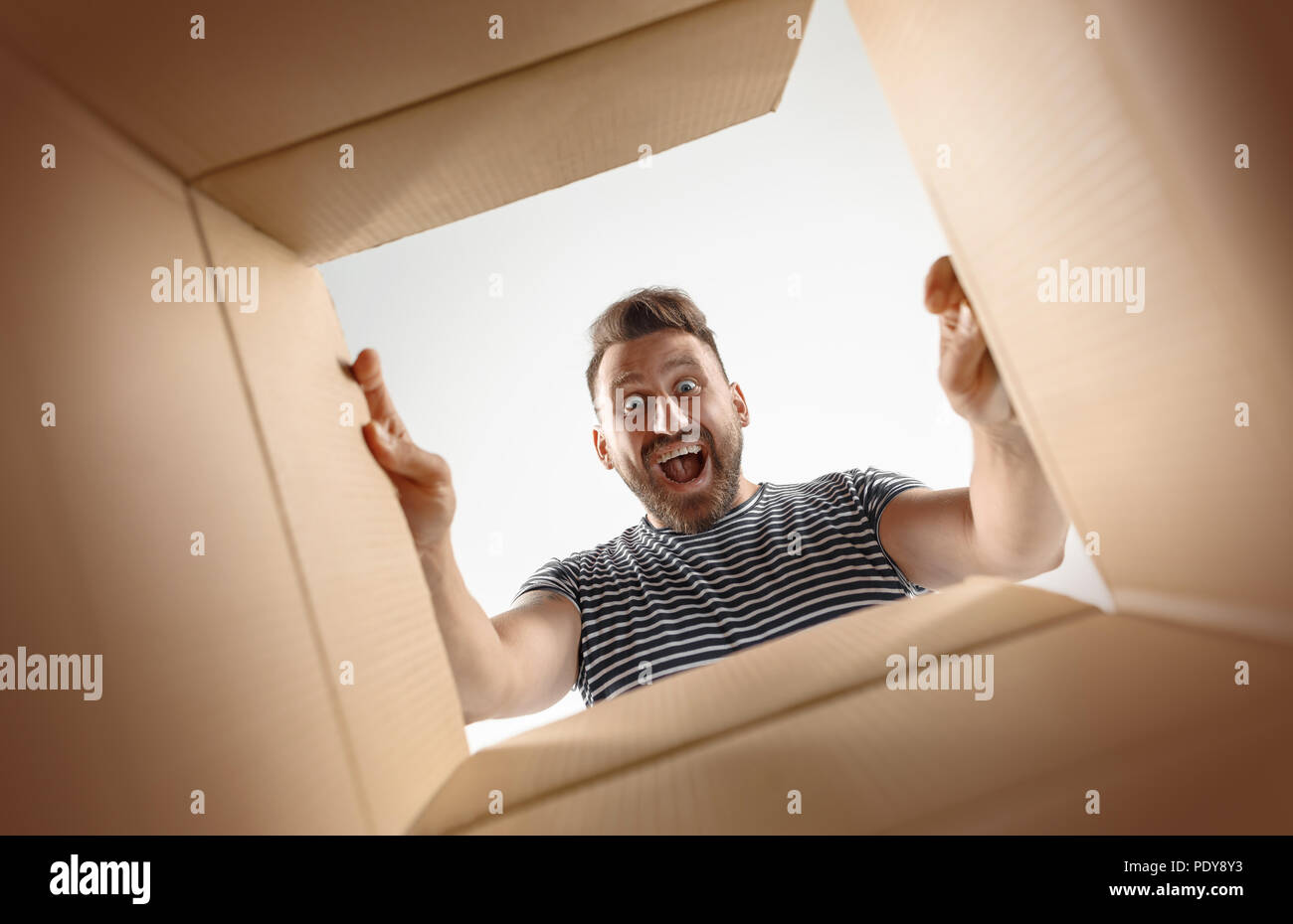 The surprised man opening carton box and looking inside. The package ...