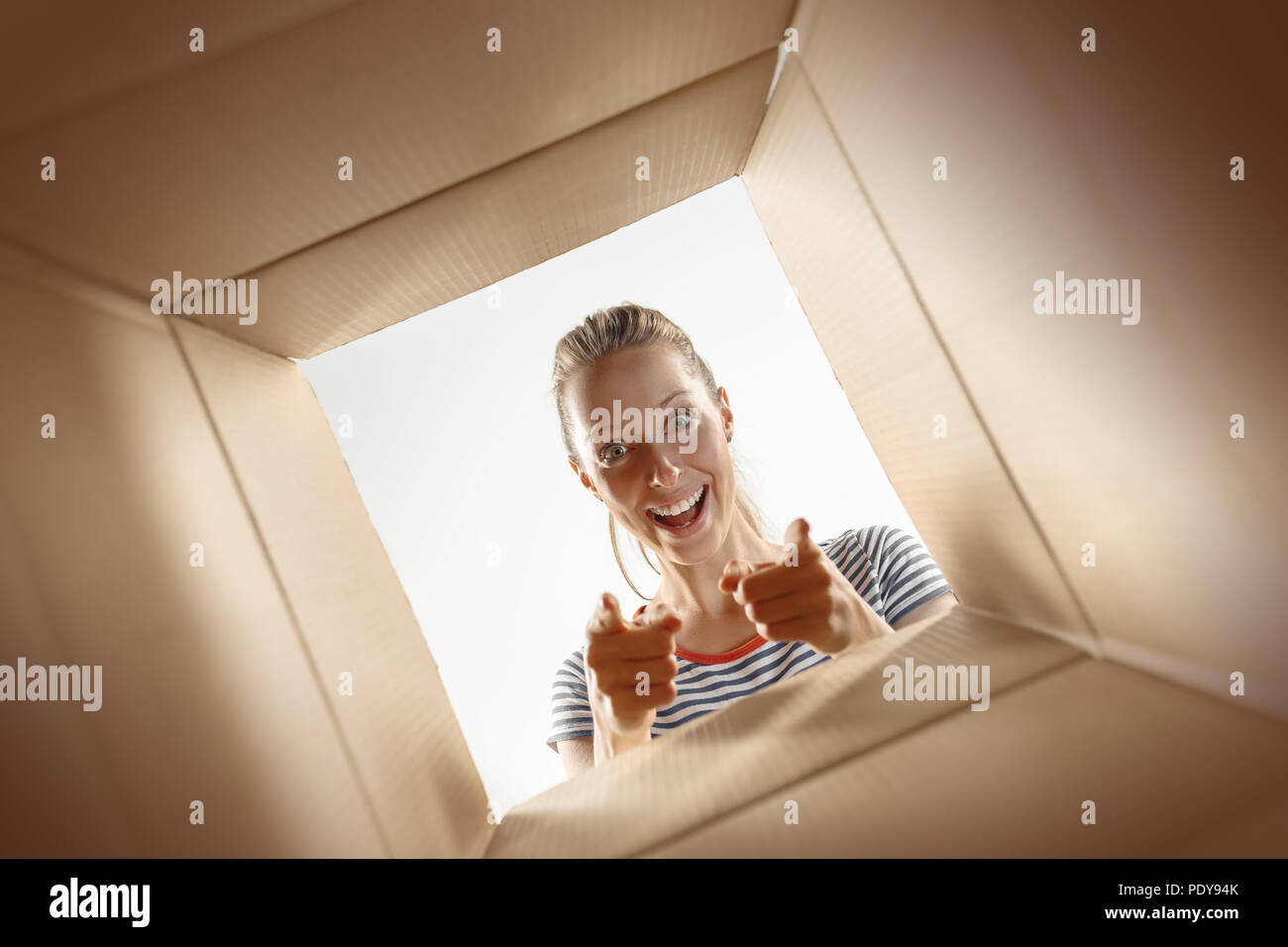 The surprised woman opening box and looking inside. The package ...