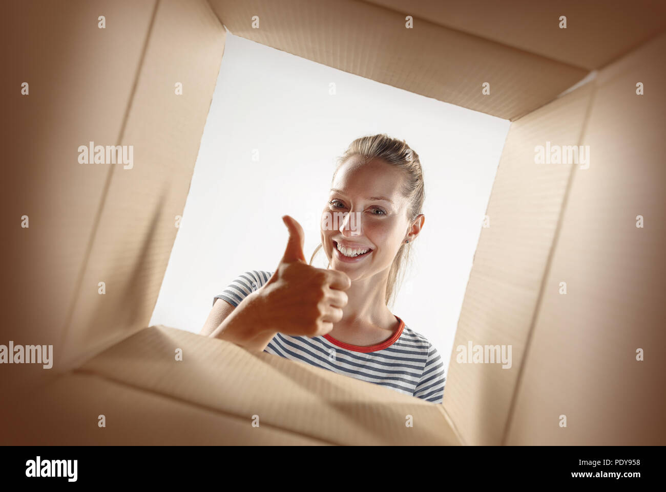 The surprised woman opening box and looking inside. The package ...