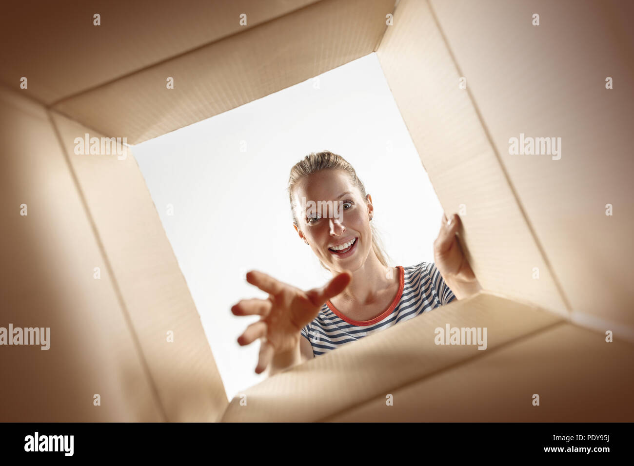 The surprised woman opening box and looking inside. The package ...