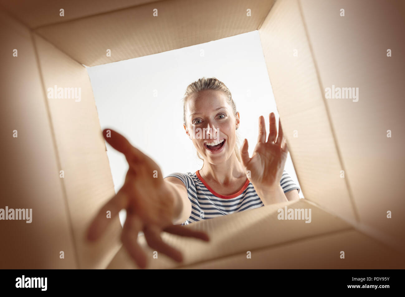 The surprised woman opening box and looking inside. The package ...