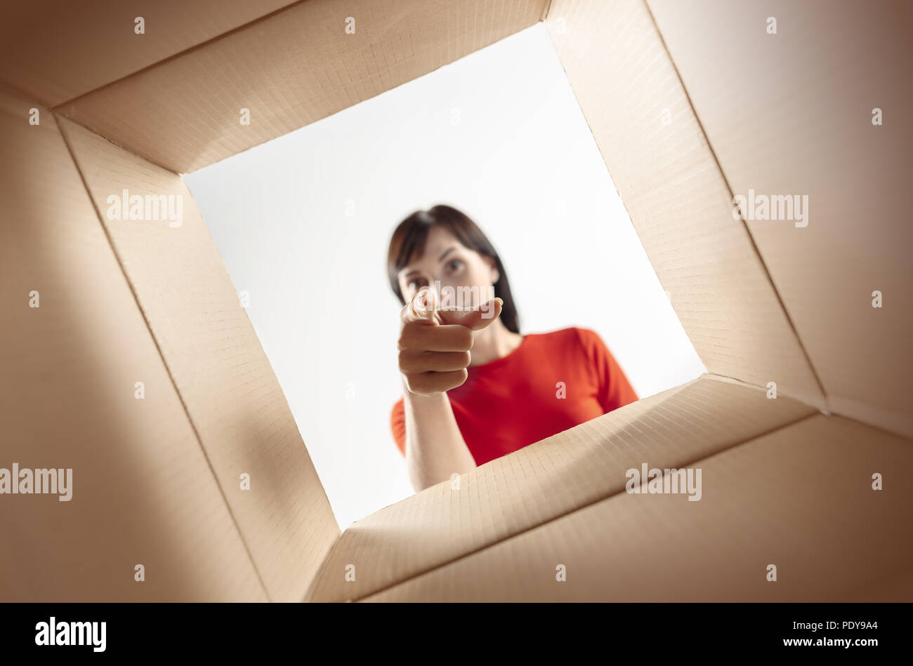 The surprised woman opening box and looking inside. The package ...