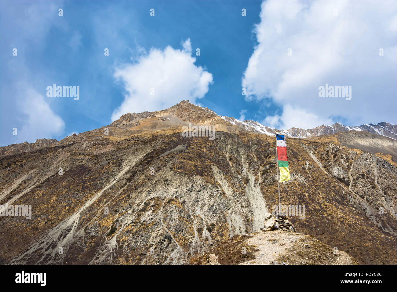 Small stupa, built of stone with a flag on the background of snowy ...