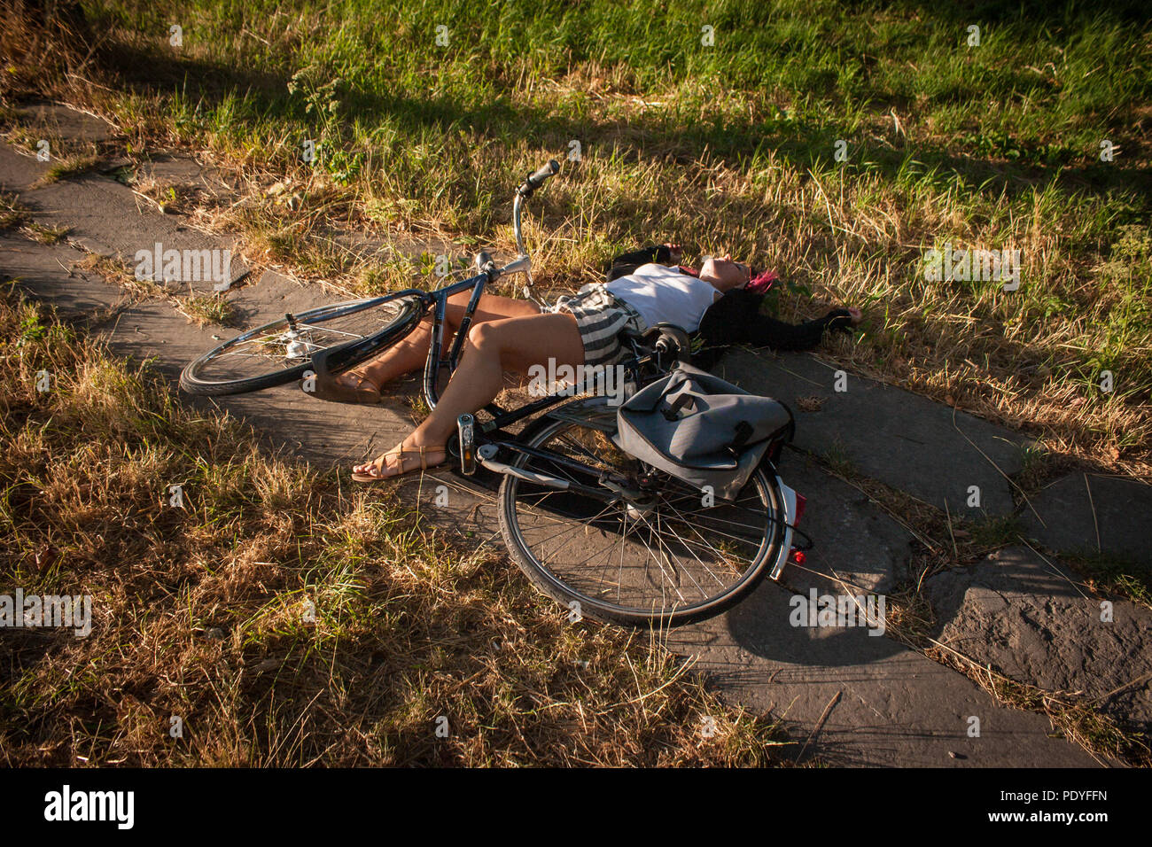 A young woman falls from her bike near a river at sunrise Stock Photo ...