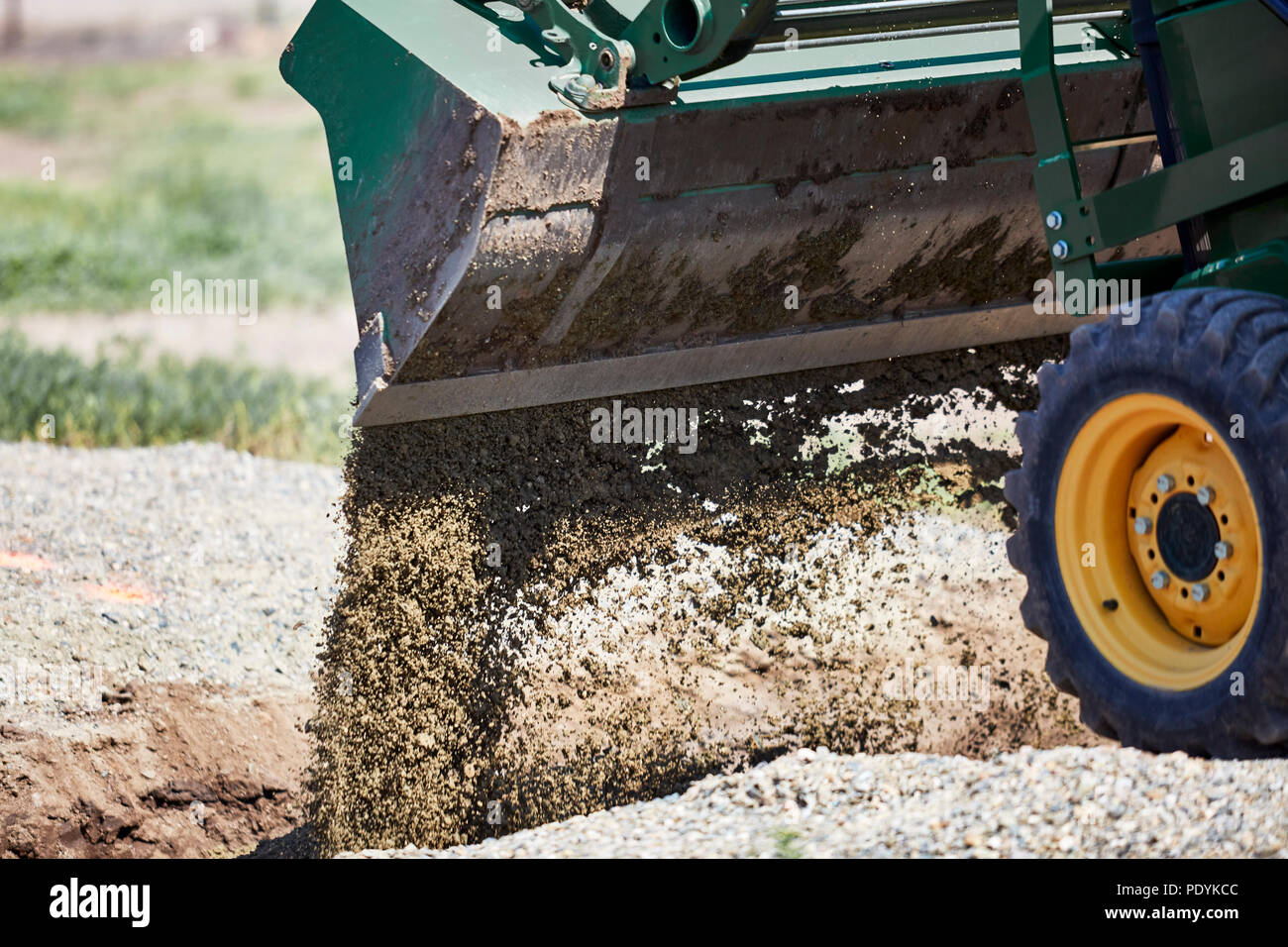 Close up of a tractor bucket dumping dirt onto a pile Stock Photo - Alamy