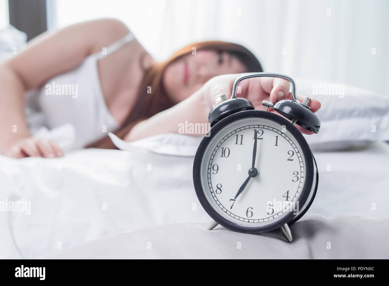 Young sleeping woman and alarm clock in bedroom at home Stock Photo - Alamy