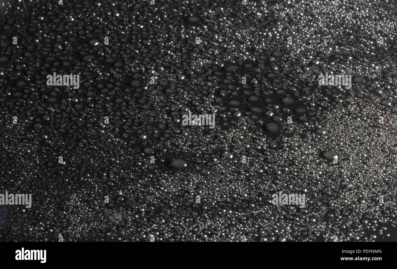 Water moister and dew on a black surface. Collecting droplets of water ...