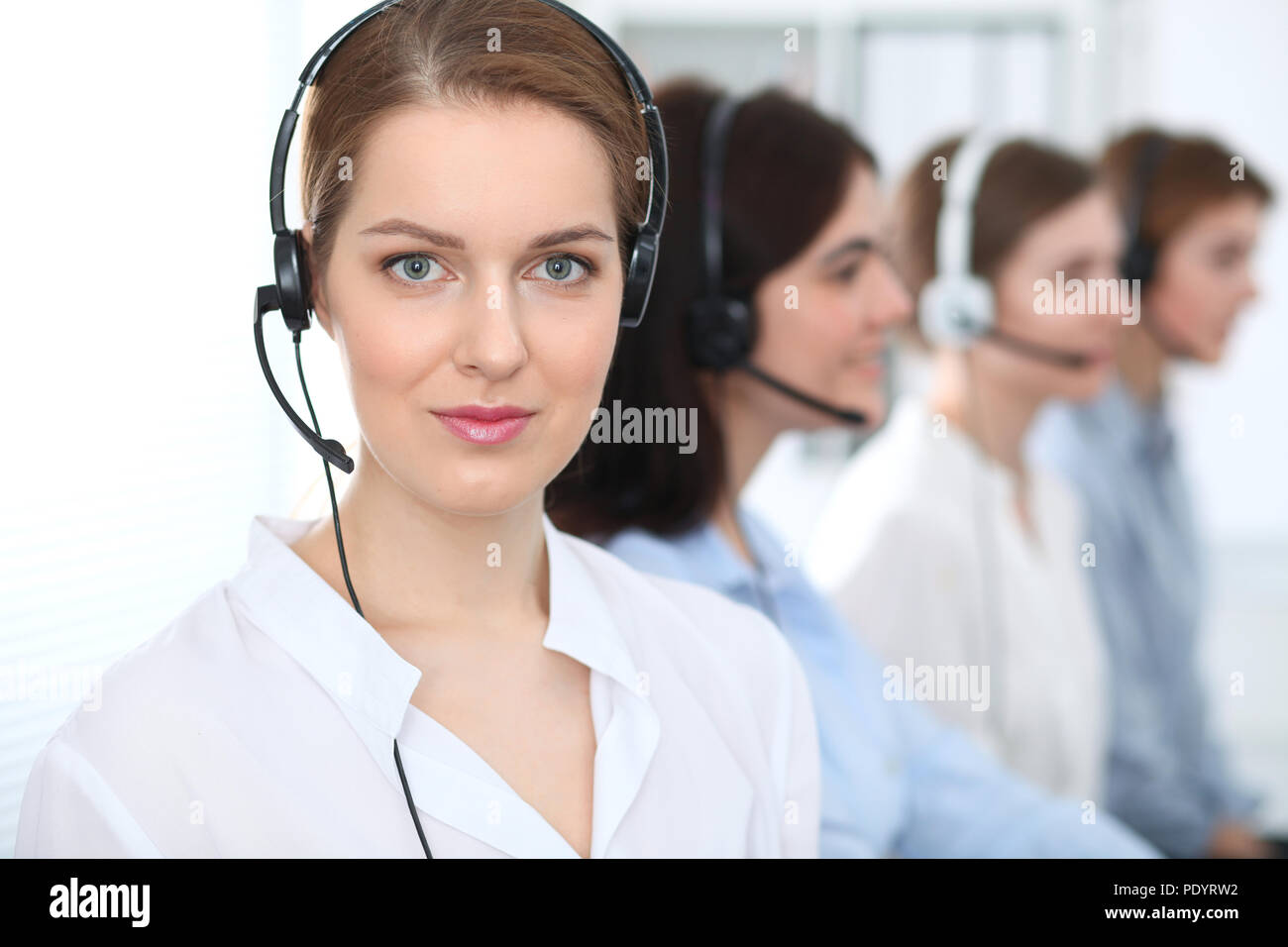 Call center. Beautiful cheerful smiling operator consulting clients ...