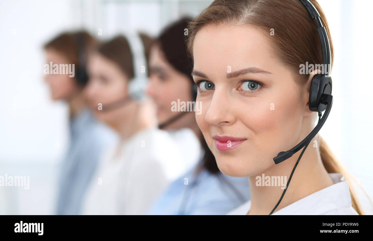 Call center. Beautiful cheerful smiling operator consulting clients ...