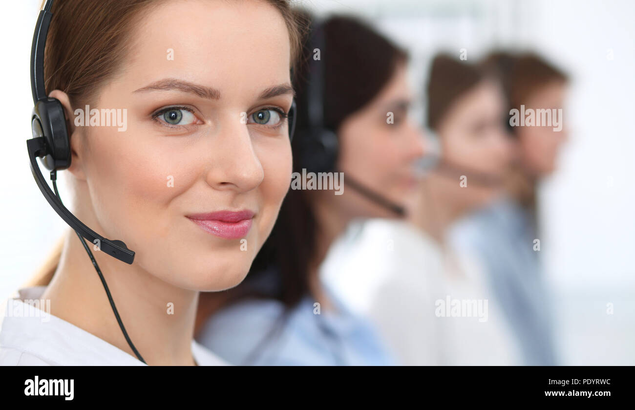 Call center. Beautiful cheerful smiling operator consulting clients ...