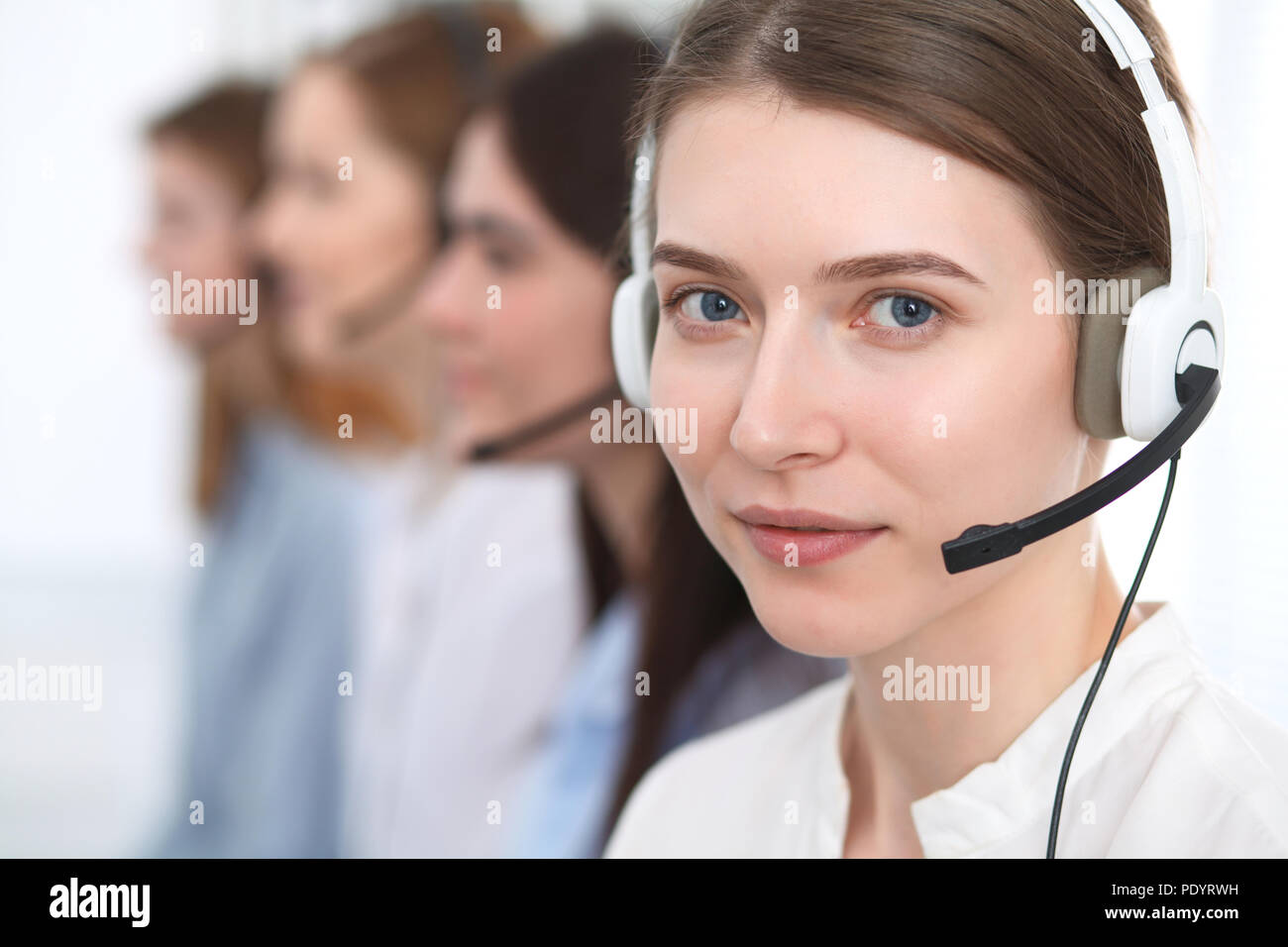 Call center. Beautiful cheerful smiling operator consulting clients ...