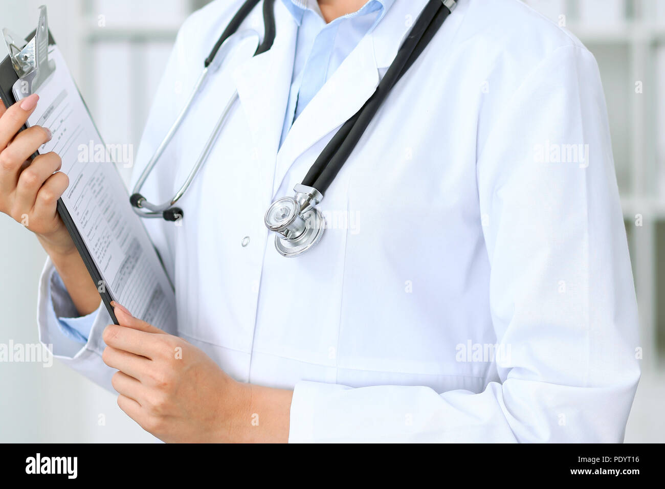Closeup of unknown doctor woman standing with medication history ...