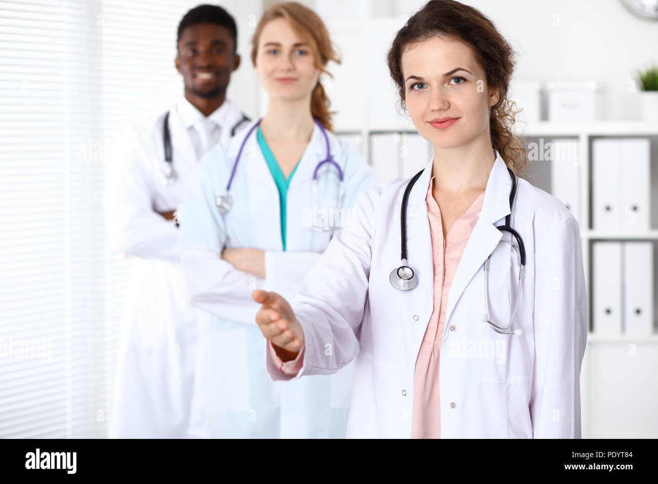 Medical team of confident doctors showing Ok sign with thumbs up ...