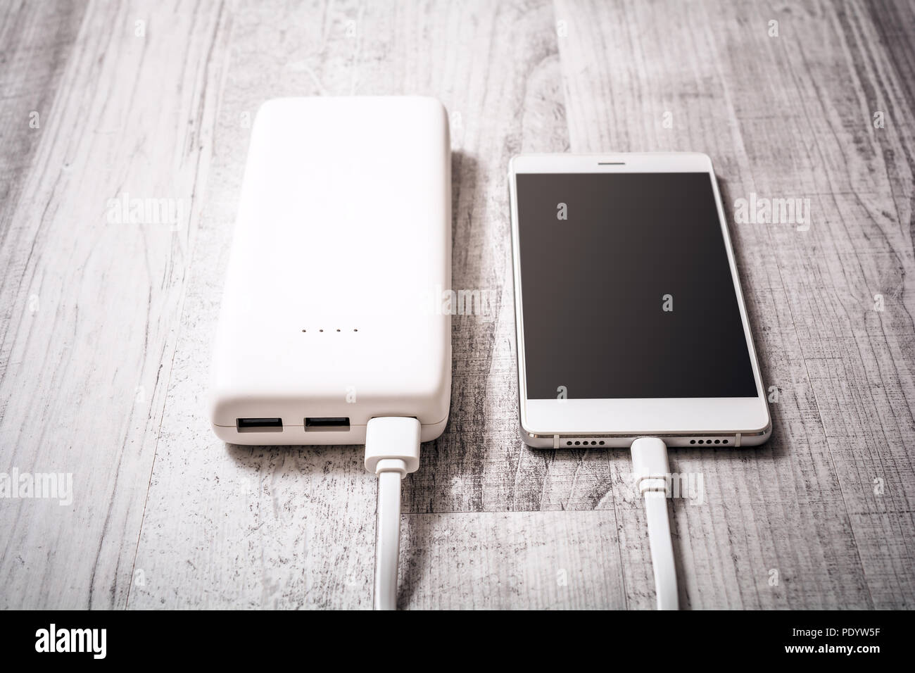 Smartphone On A Table Getting Recharged By A Powerbank, High Angle View ...