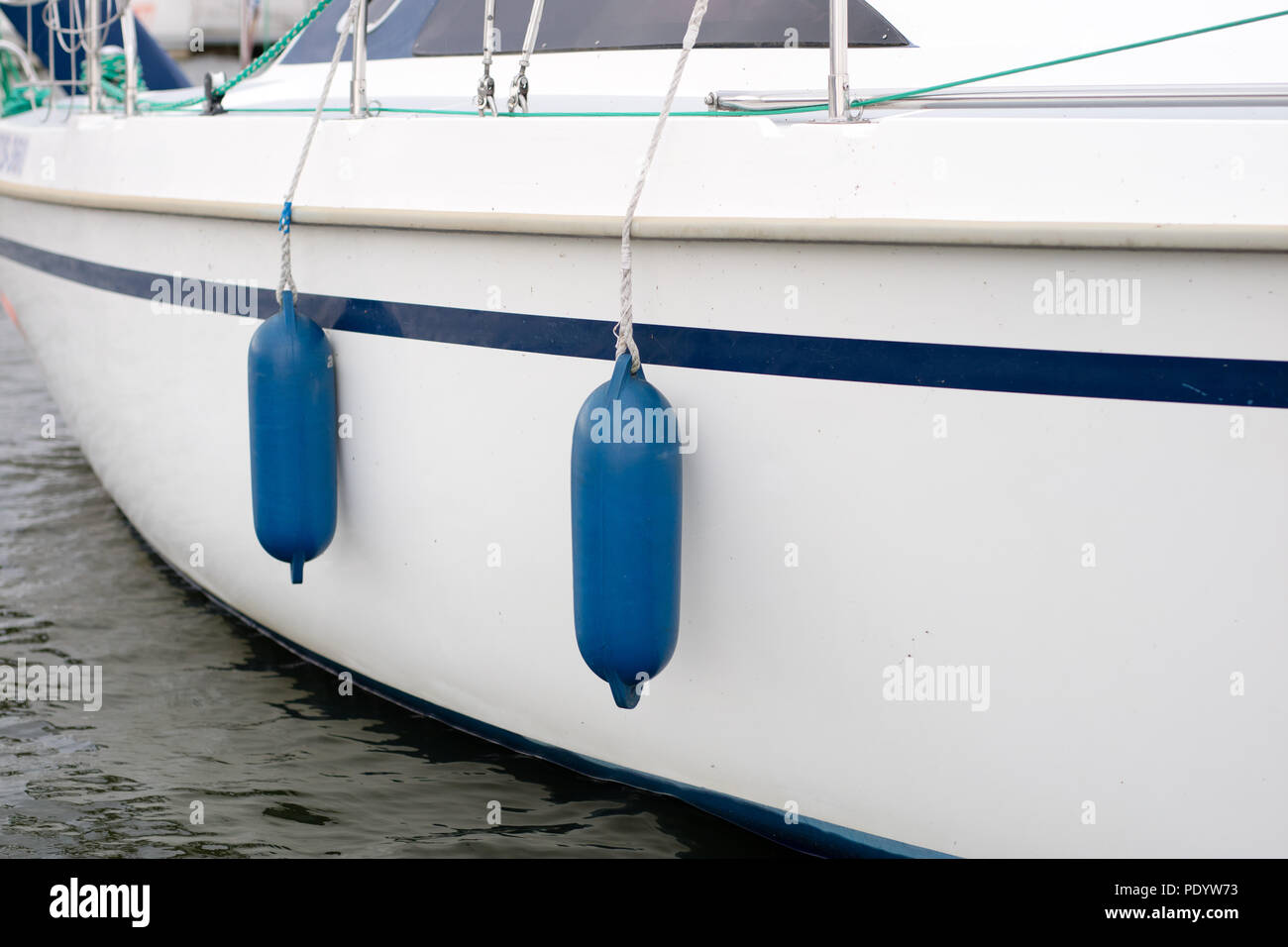 Bumpers hung at the side of the yacht. Moored and secured boats at the ...