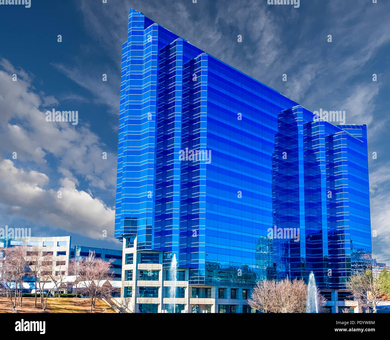 A beautiful modern blue glass building with a fountain in front Stock ...