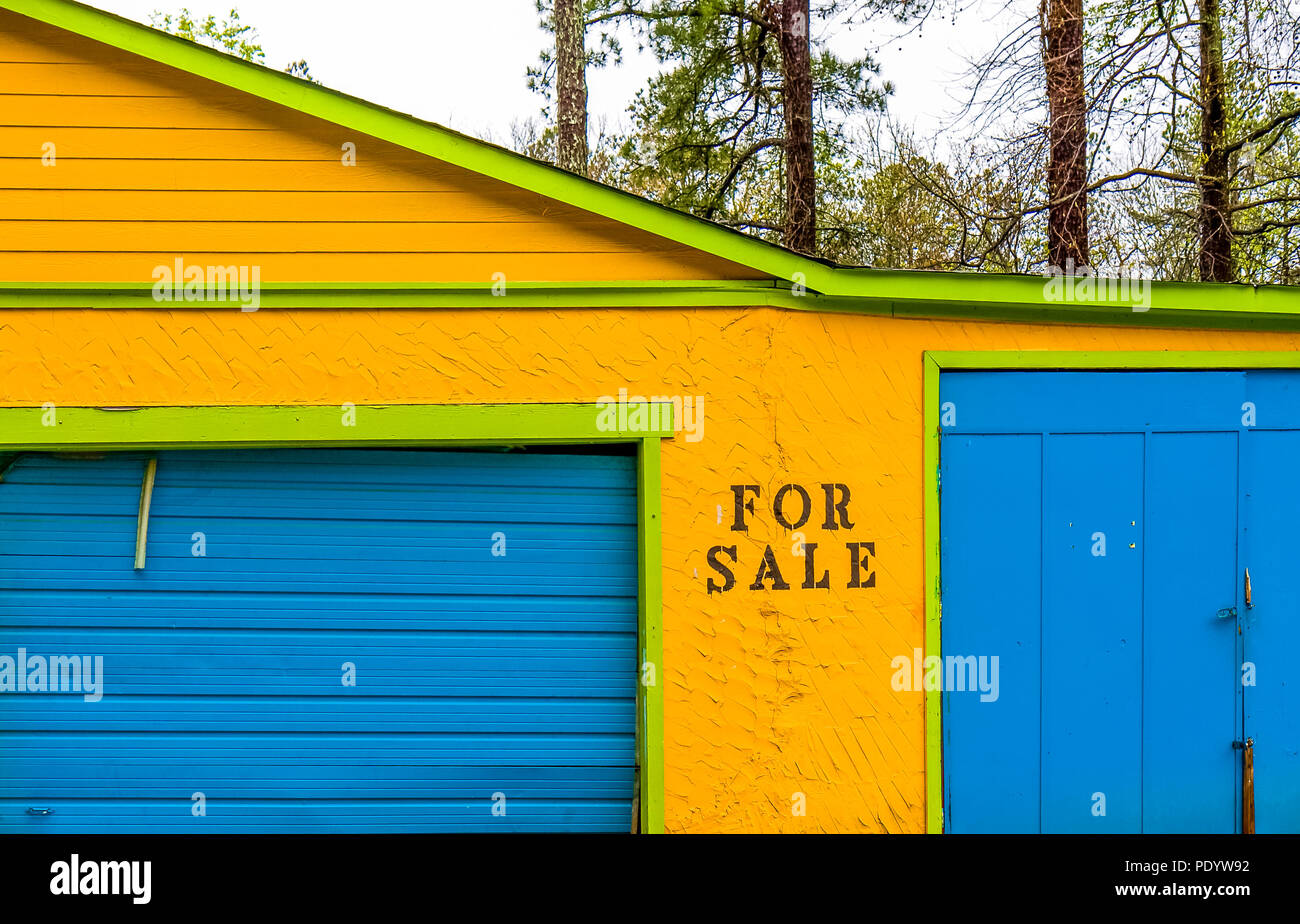 an old warehouse painted yellow and blue with for sale sign Stock Photo ...