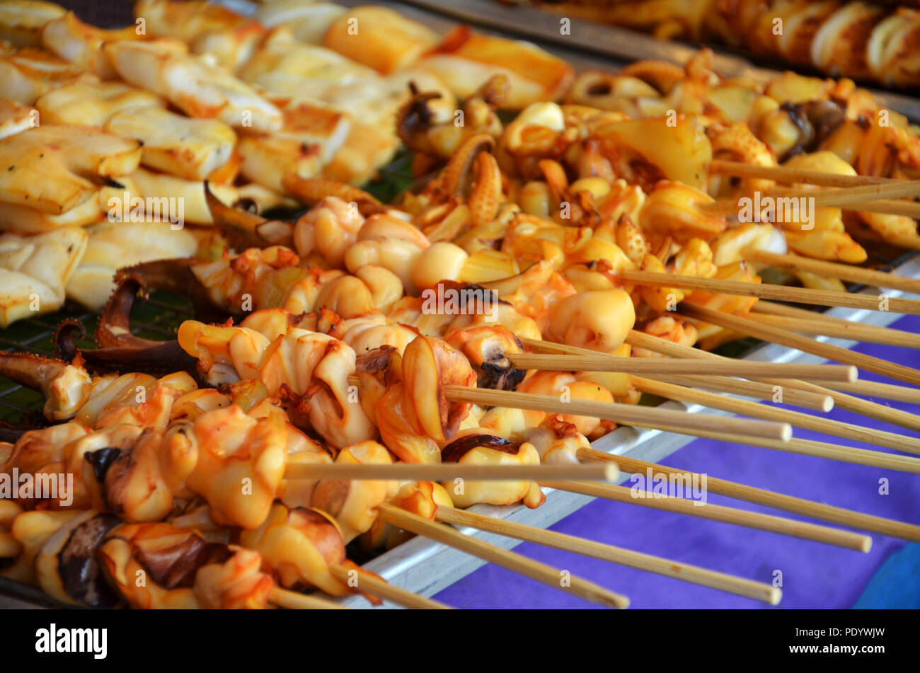 Grilled squids on stick, Thai street food Stock Photo - Alamy