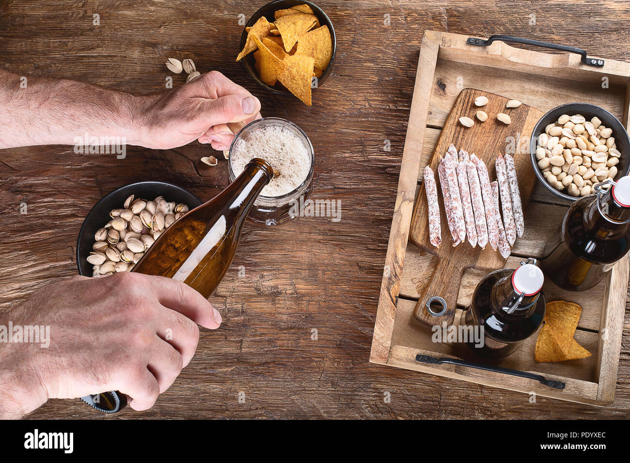 Man pouring beer into glass from bottle Stock Photo - Alamy