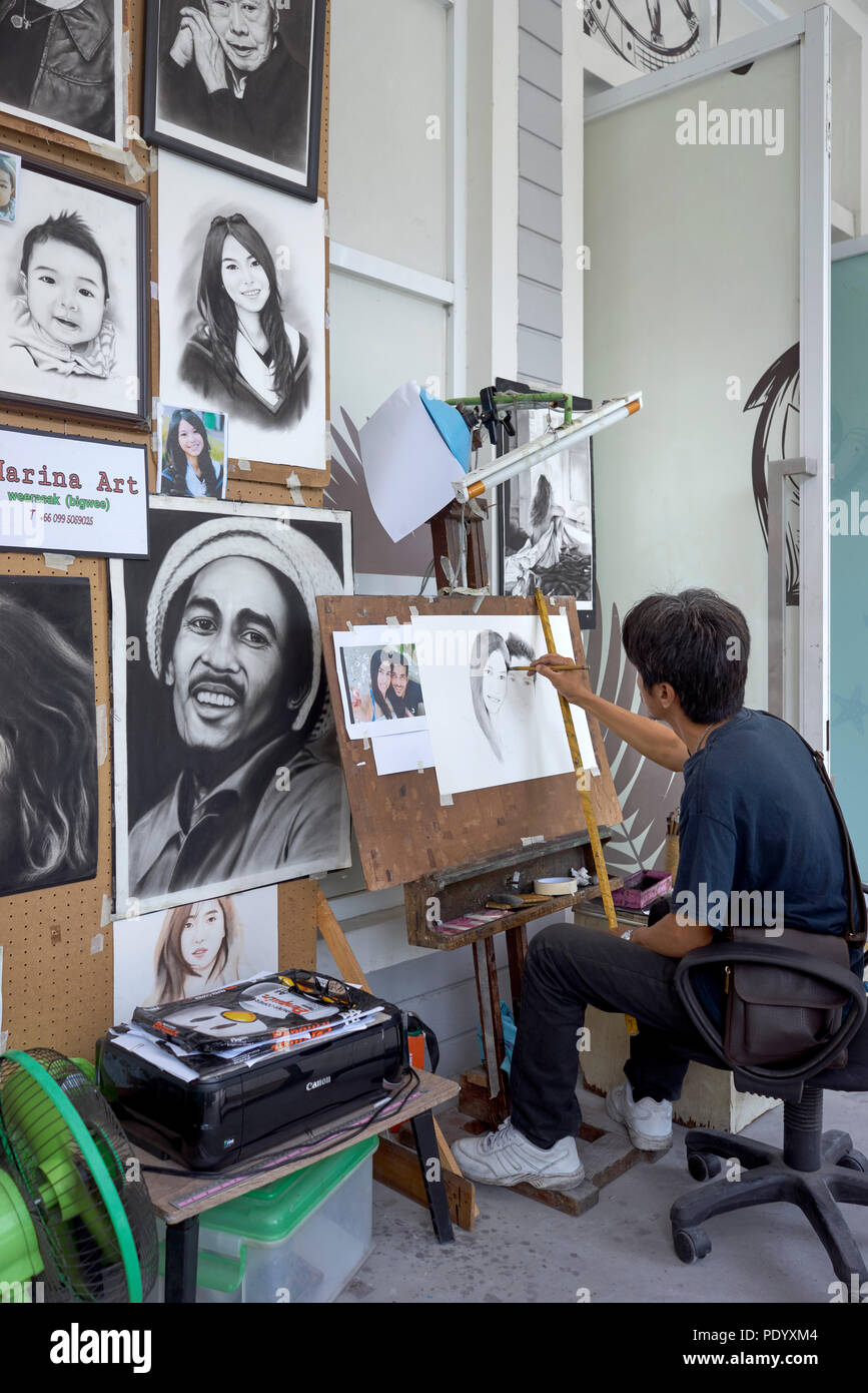 Artist studio. Artist at work in a studio with a vast array of his work ...