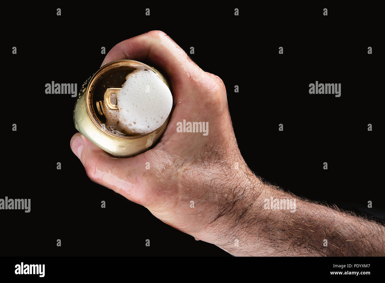 Beer can in hand on black background Stock Photo - Alamy