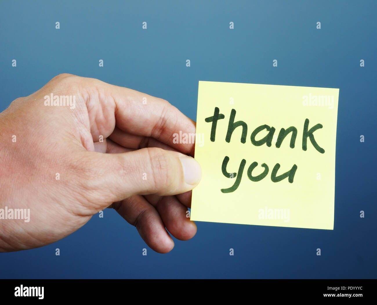 Hand is holding memo stick with sign Thank you Stock Photo - Alamy