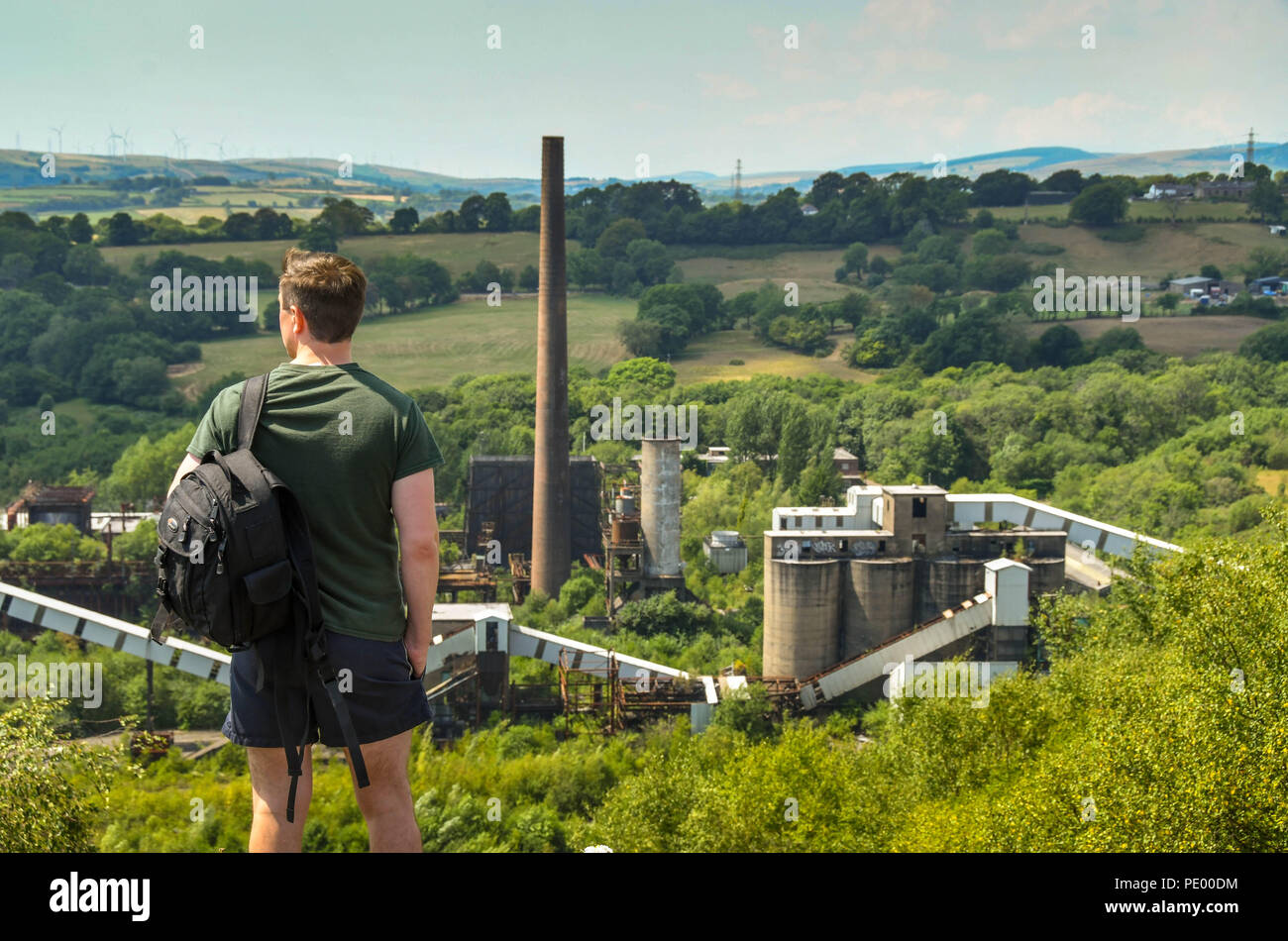 Person standing on a hillside overlooking the derelict building on the ...