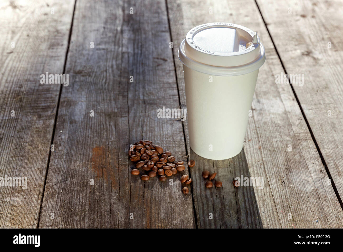 Paper cup and grains of coffee on wooden background Stock Photo - Alamy
