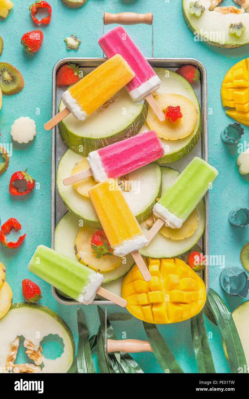 Tray with colorful Ice cream popsicles with fresh sliced fruits and ...