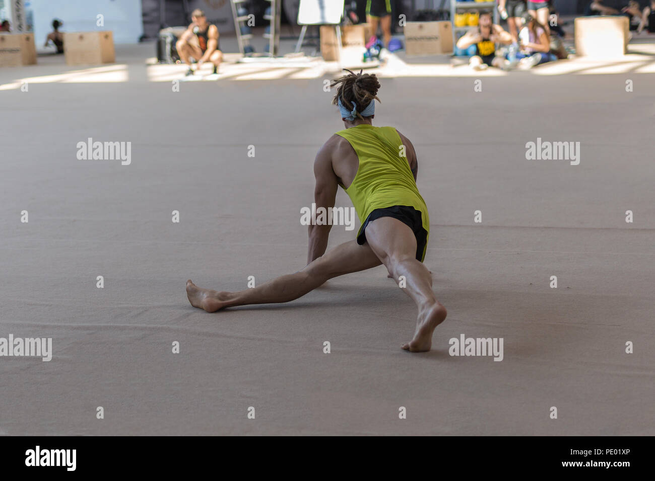 Young Man with Rasta Hair Exercising on the Floor at Gym: Back view ...