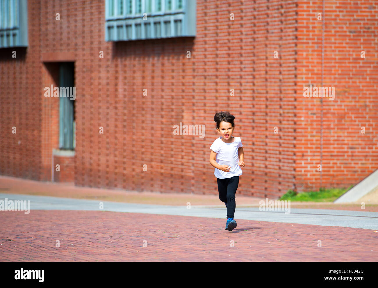 Little child having fun by running on the streets Stock Photo - Alamy