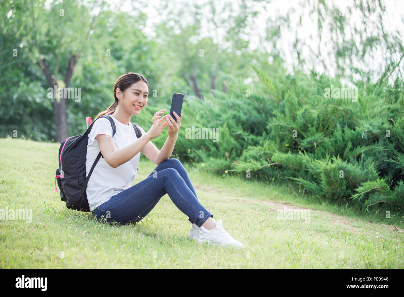 Asian women sitting on lawn Stock Photo - Alamy