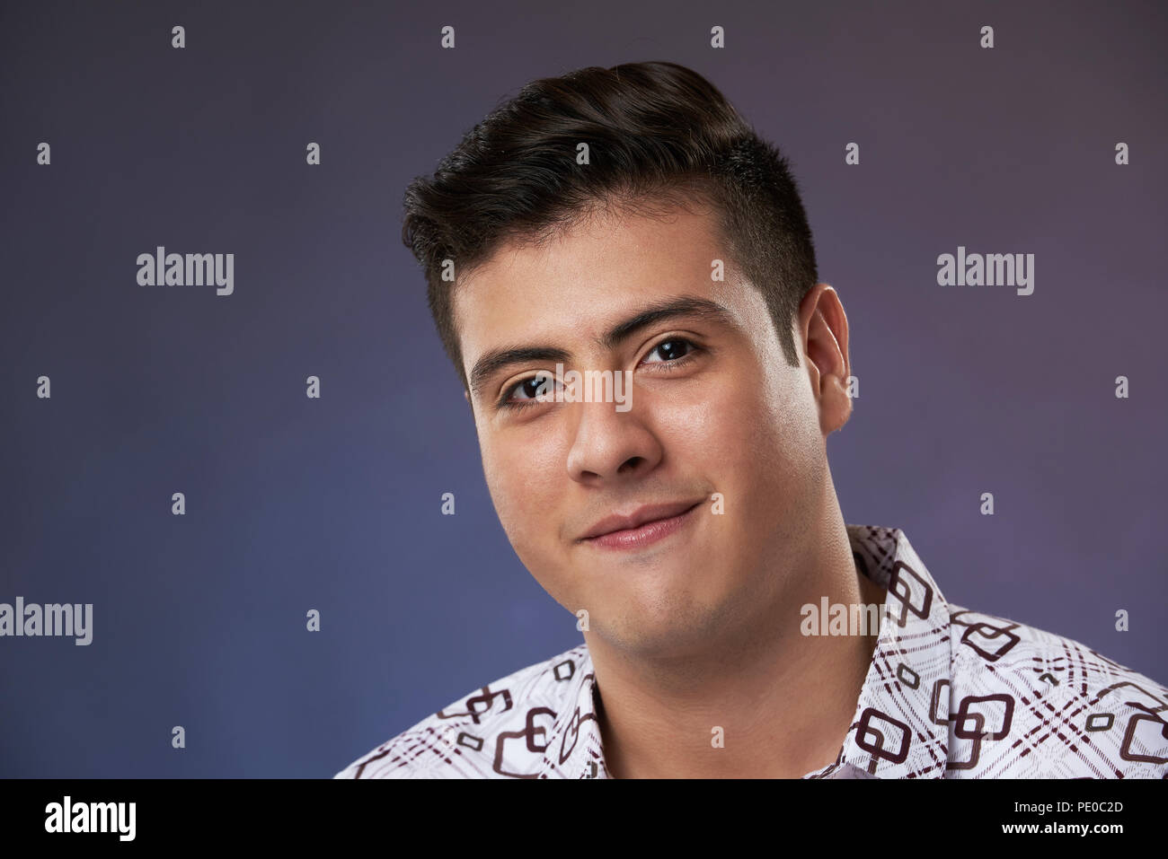 Serious young man portrait on dark blue studio background Stock Photo ...
