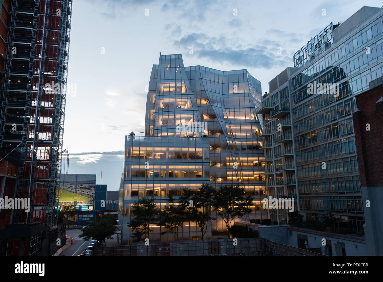 Modern glass building brightly lit from the inside at sunset in the ...