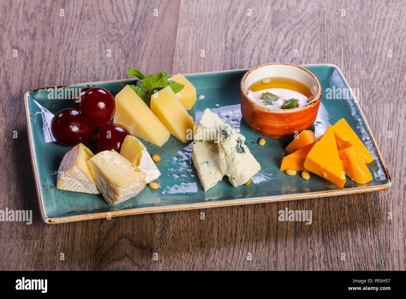 Cheese plate mix assortment with grape and honey Stock Photo - Alamy