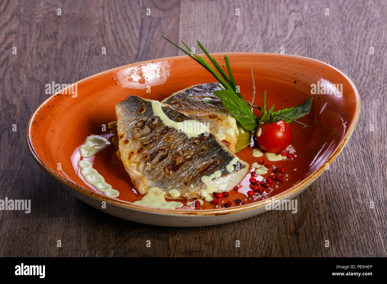 Grilled dorada fillet served tomato and onion Stock Photo - Alamy