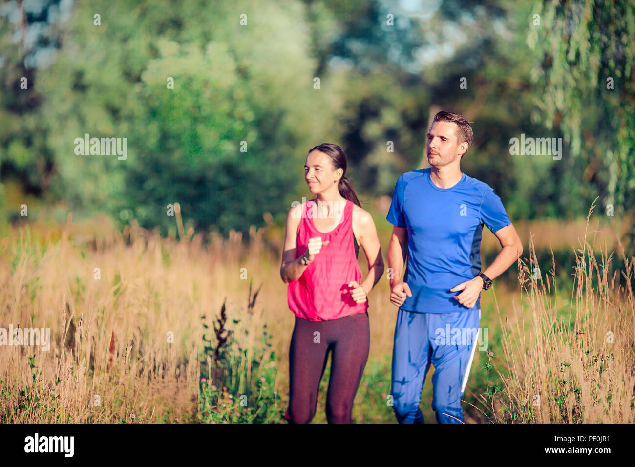 Active sportive couple running in park. Athletic family running ...