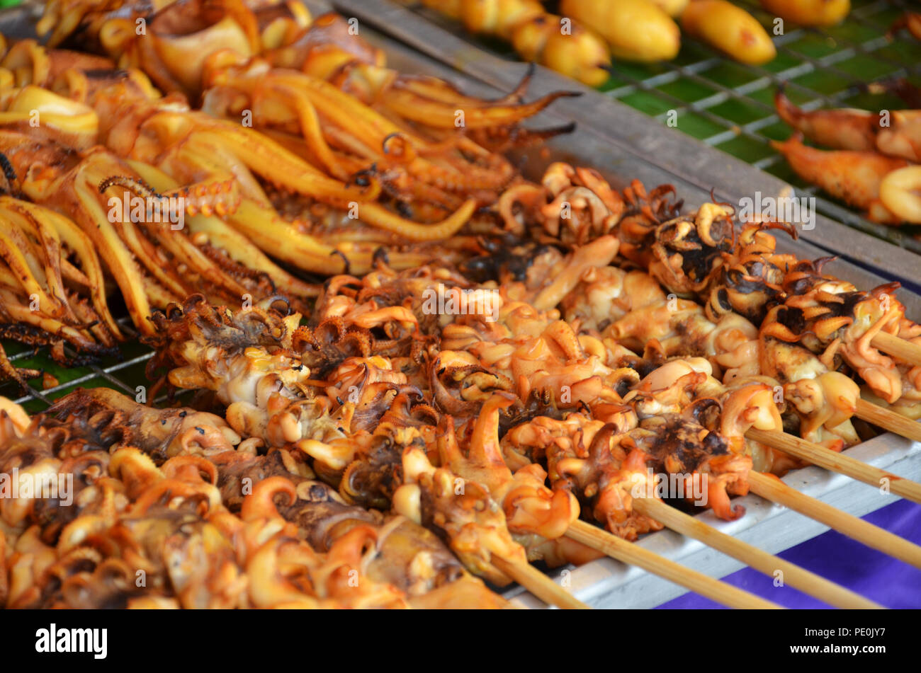 Grilled squids on stick, Thai street food Stock Photo - Alamy