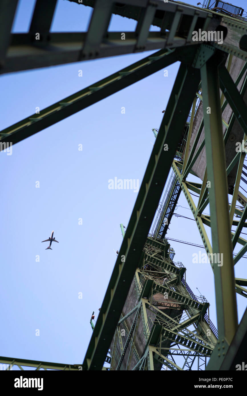 An airplane in the sky flies over Columbia Interstate lifting bridge ...