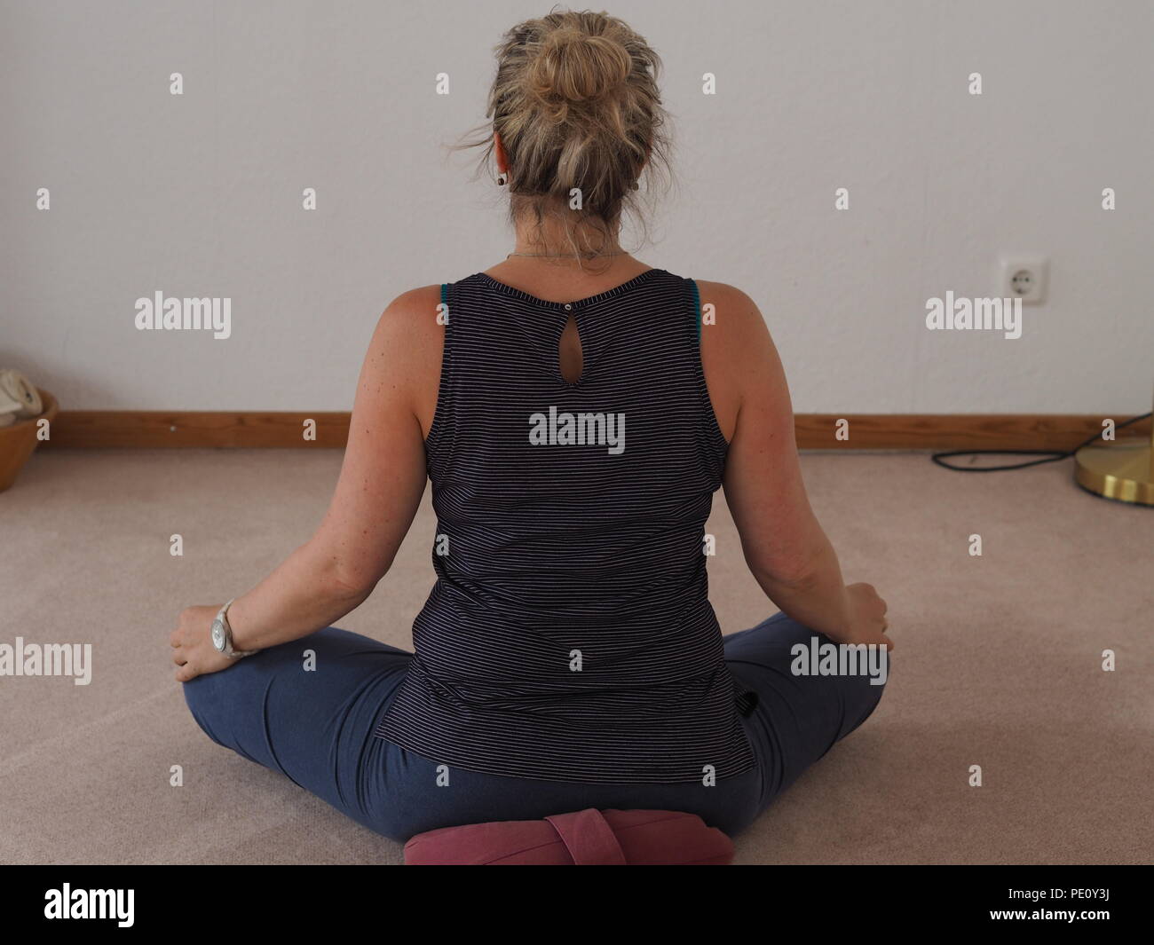 Woman from behind in a sitting yoga pose Stock Photo - Alamy